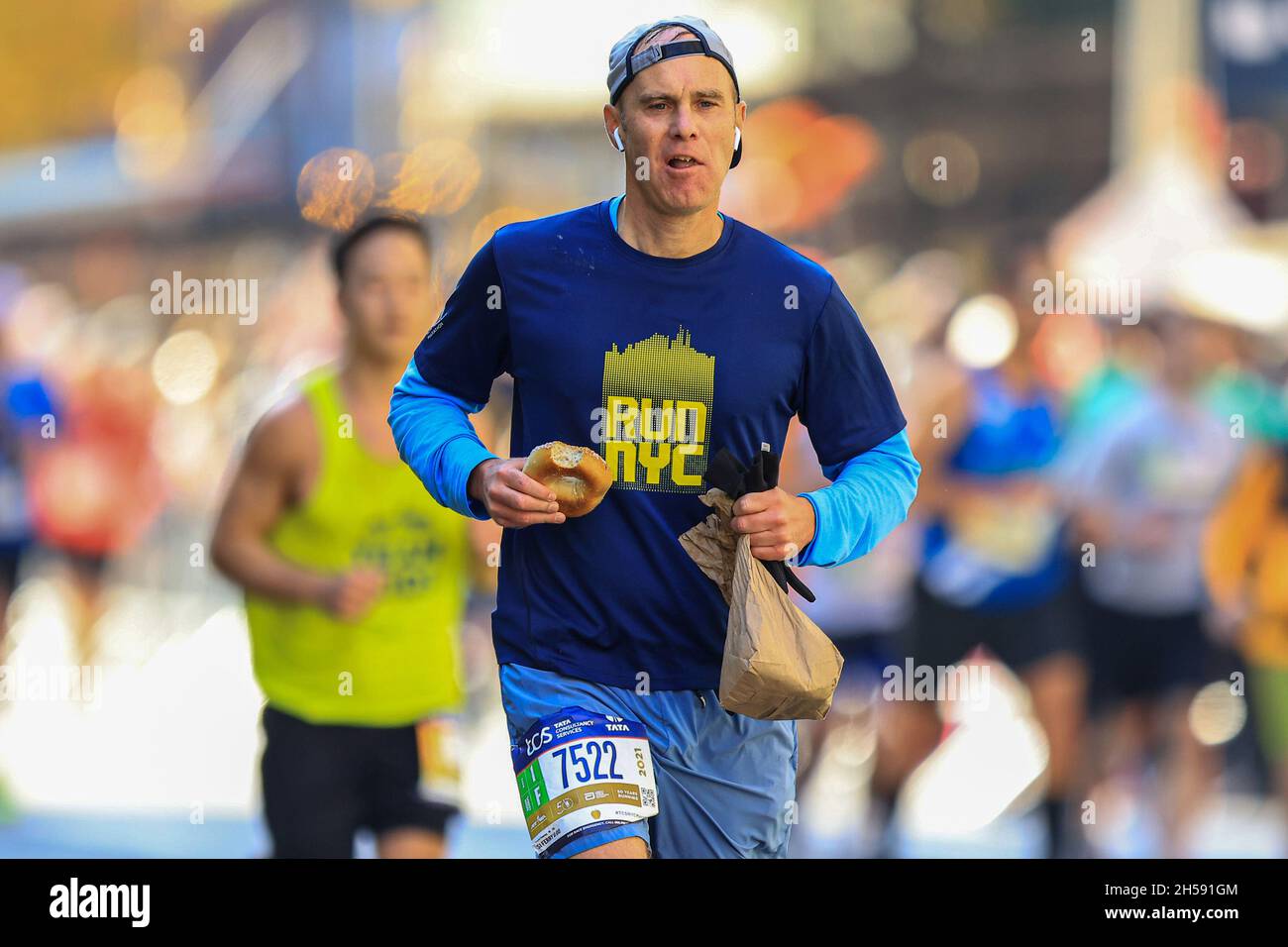 New York, N.Y/USA – 7th Nov. 2021: A runner enjoys a bagel on First ...