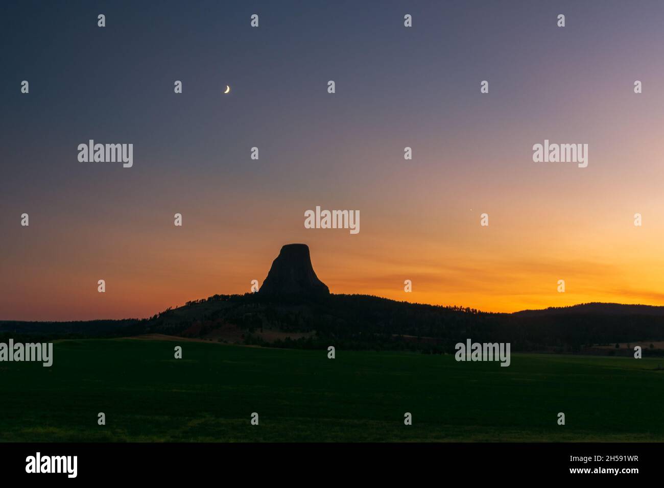 Devils tower silhouetted underneath moon at sunset, Devils Tower ...