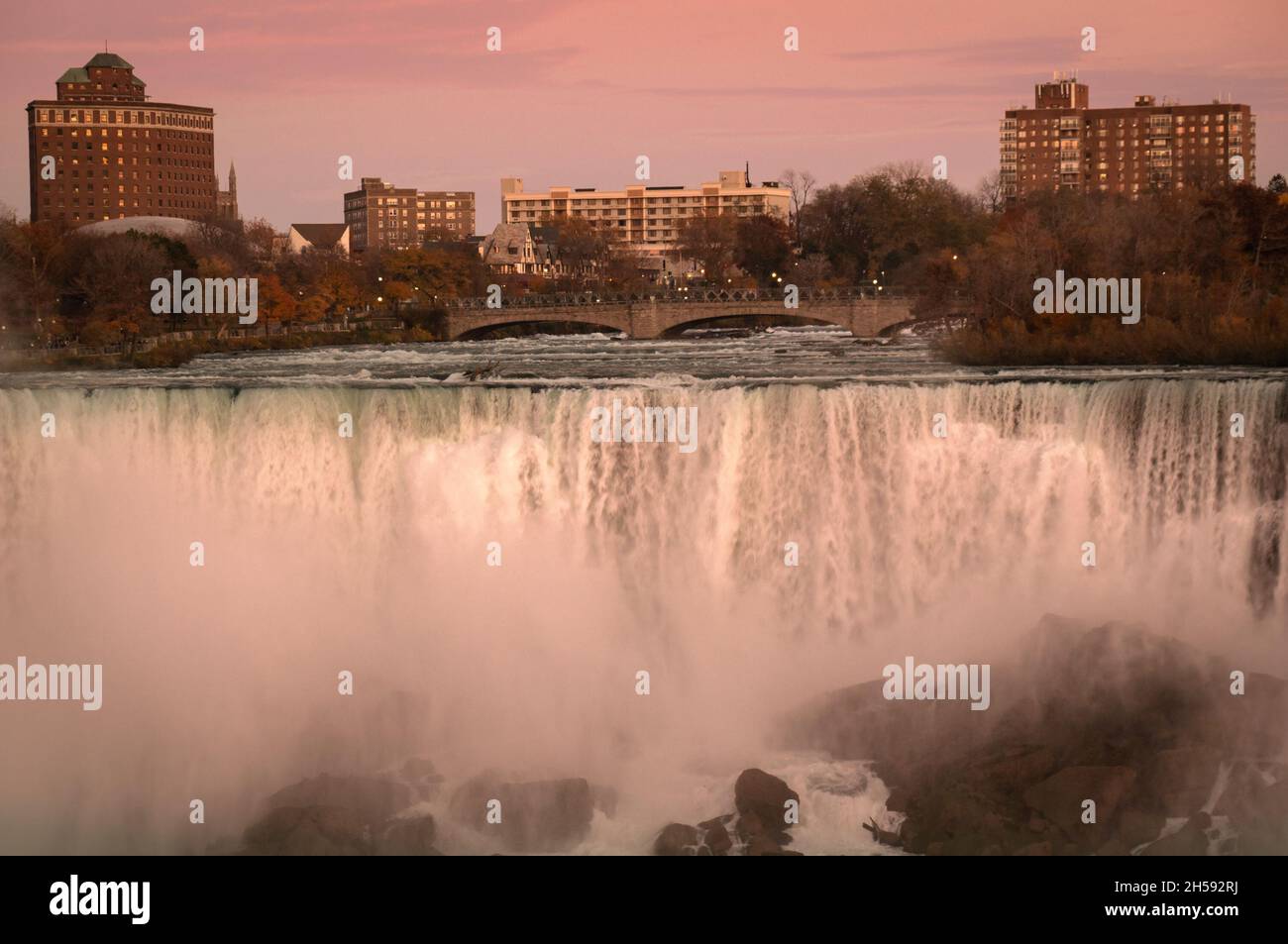 Sunset view of American Niagara Falls waterfall in front of high rise ...