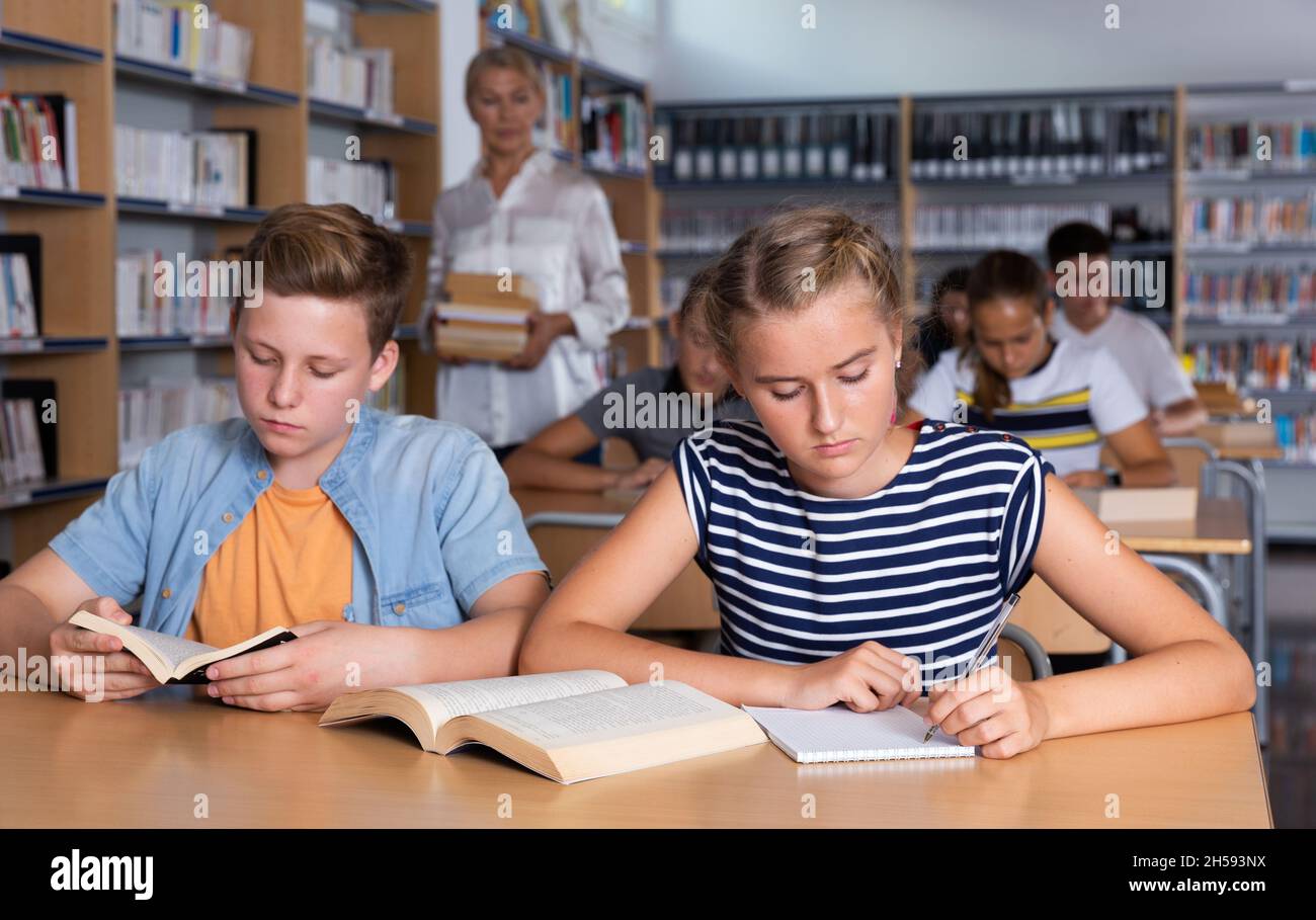 Schoolchildren preparing for lesson in school library Stock Photo - Alamy