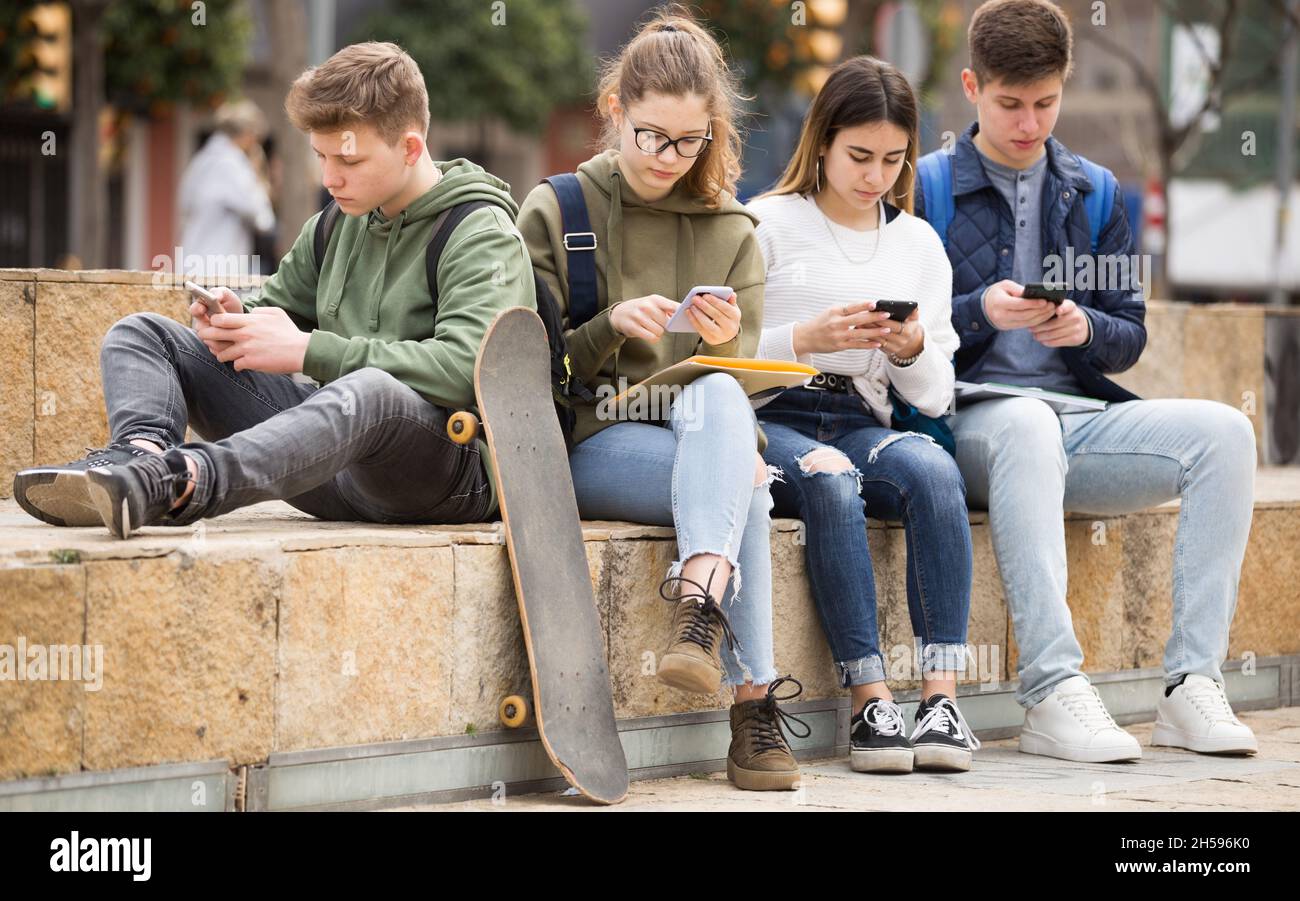 Teenage friends holding phones Stock Photo - Alamy