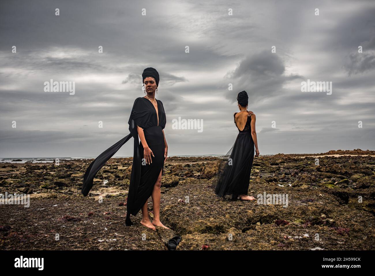Woman seen standing on rocks at beach Stock Photo - Alamy