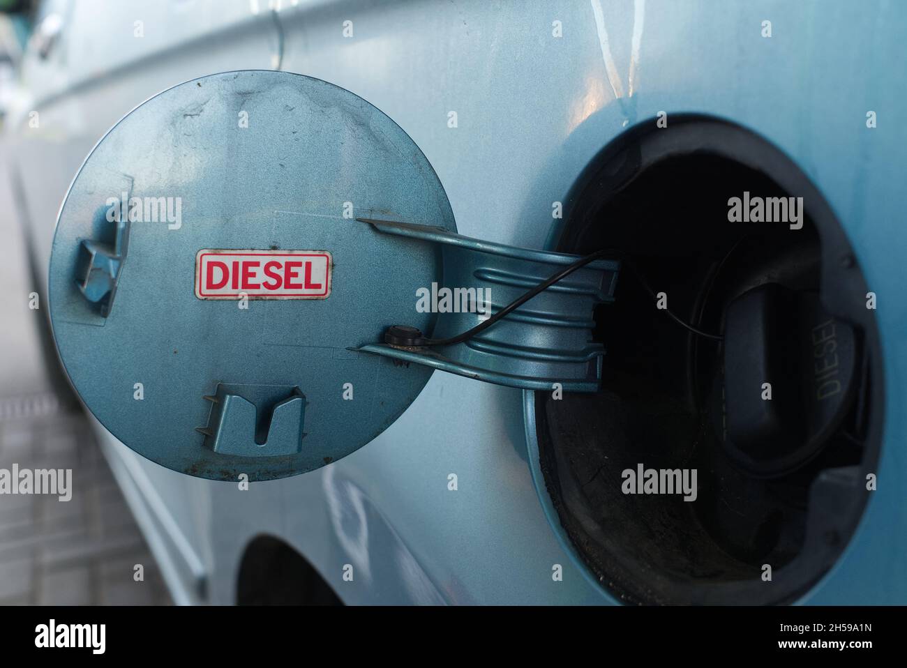 Close up on the open cap of a fuel tank of a vehicle with red sign for ...