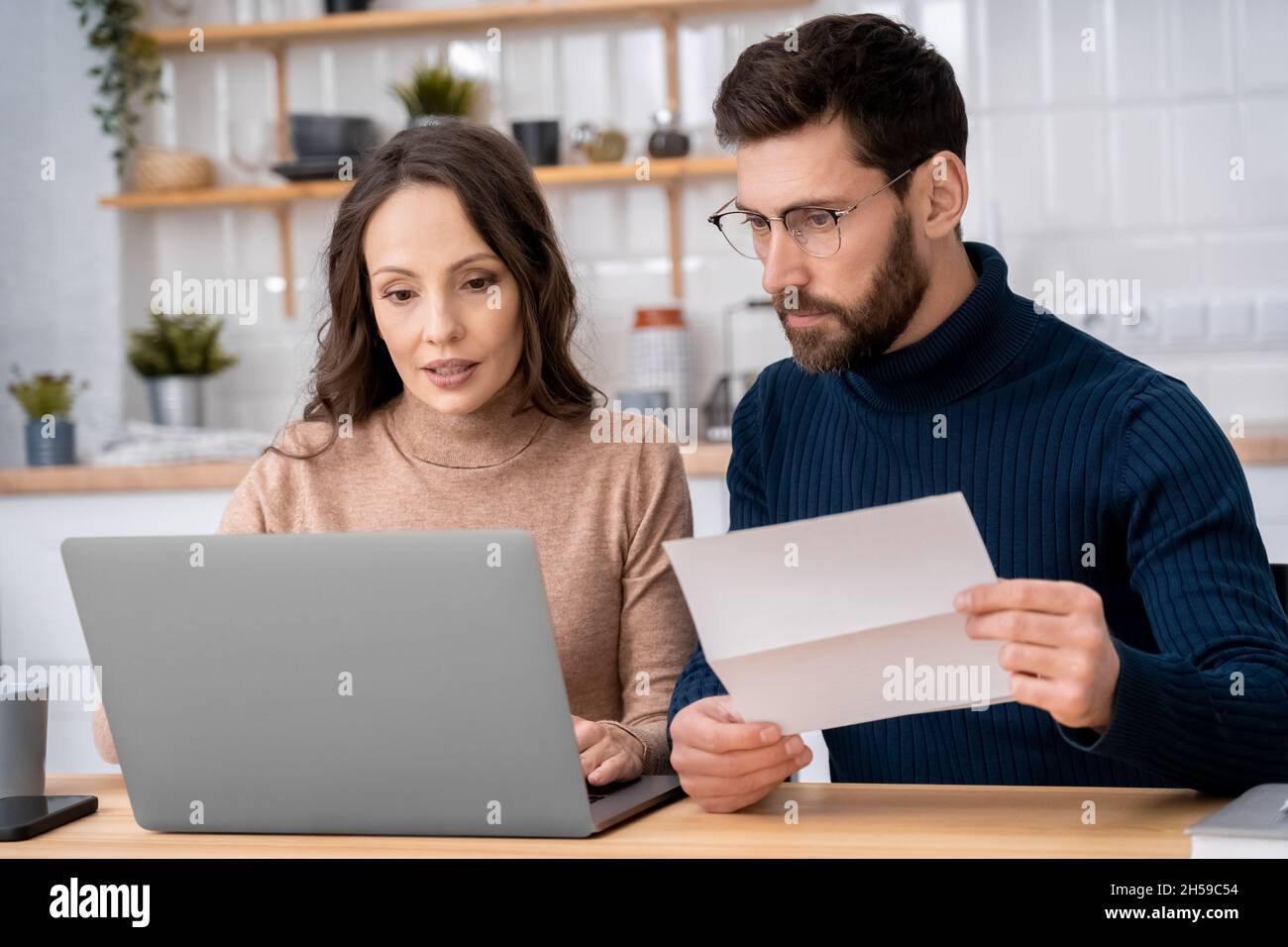 Shocked couple troubled with too high expenses utility costs looking at ...