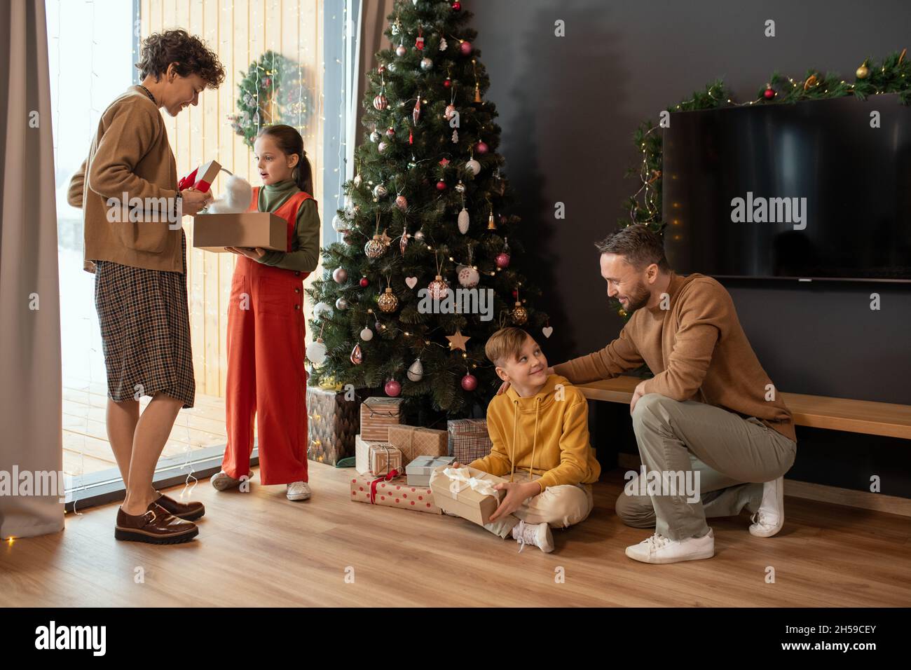 Happy family with two children opening presents while celebrating ...