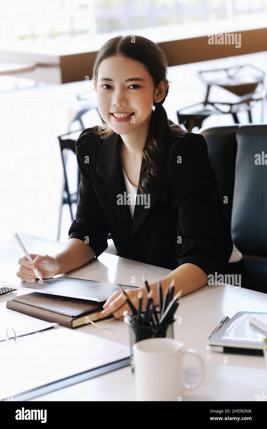 Company employees are sitting at work using tablet and documents in ...