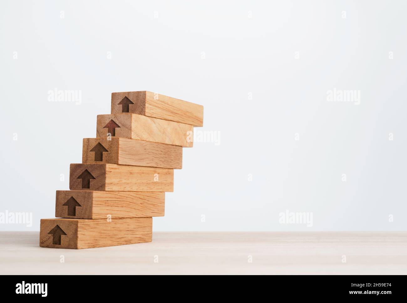 Rise up arrows on wooden blocks arranged as a steps chart on a wooden ...