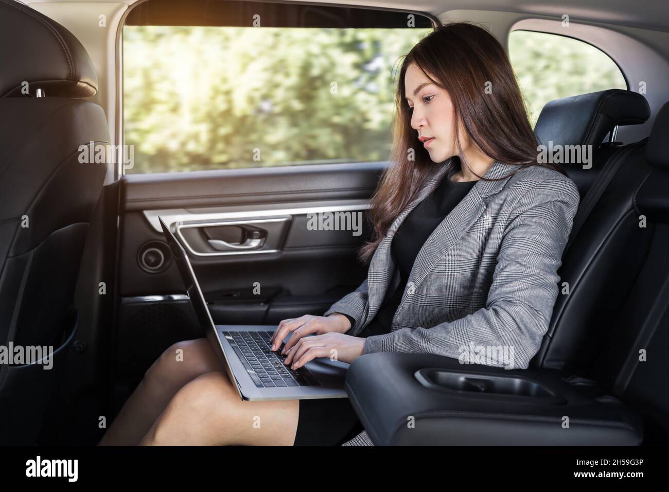 young business woman using laptop computer while sitting in the back ...