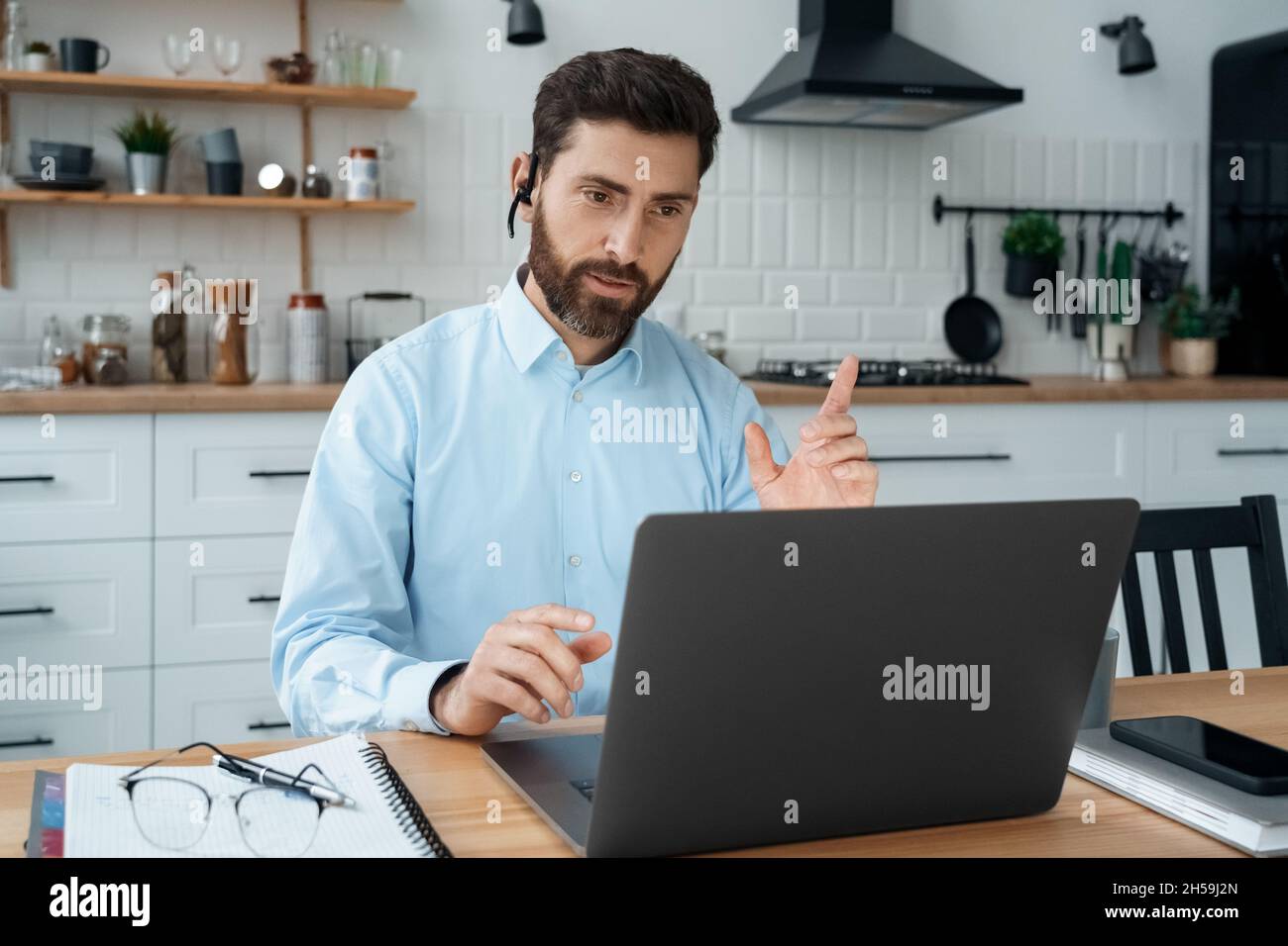 Man teacher tutor coach talking to web camera on laptop holding online ...
