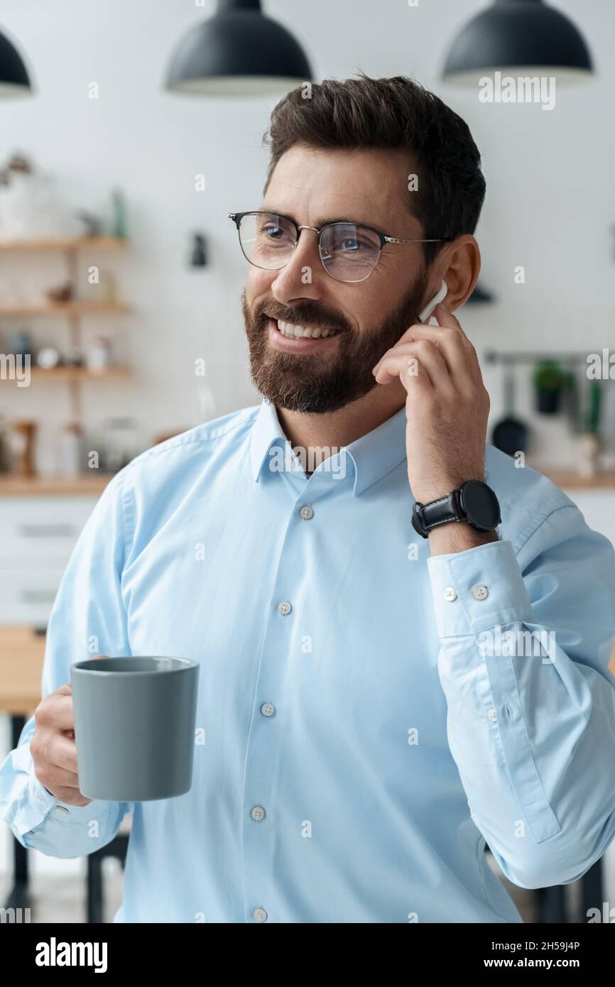 Businessman drinking coffee and having phone call on wireless ...