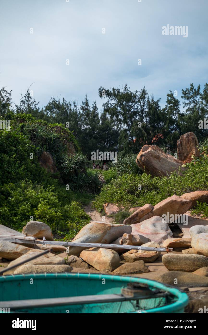 Round colourful Vietnamese fishing boats stand on the picturesque beach ...