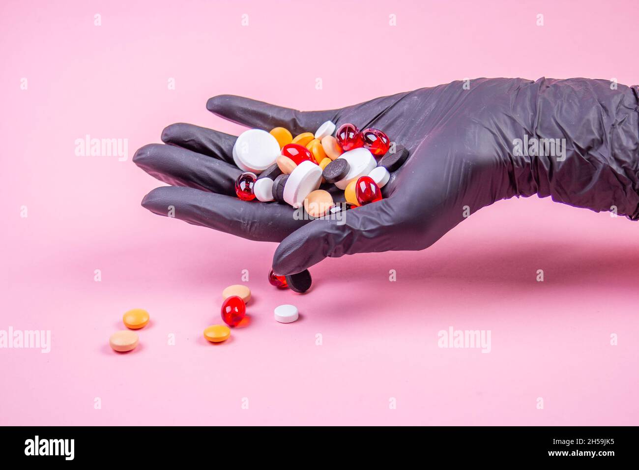 doctor's hand with black gloves holding tablets Stock Photo - Alamy