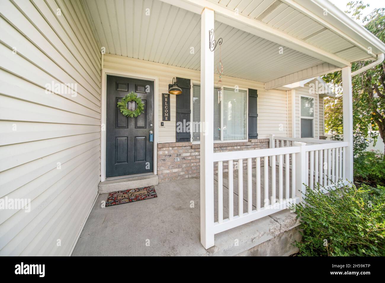 Front porch exterior of a house with bricks and wooden white posts and ...
