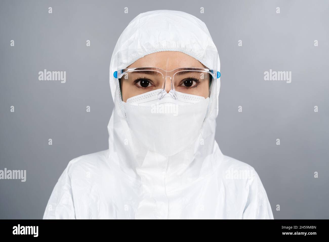 female doctor in protective PPE suit wearing face mask and face shield ...