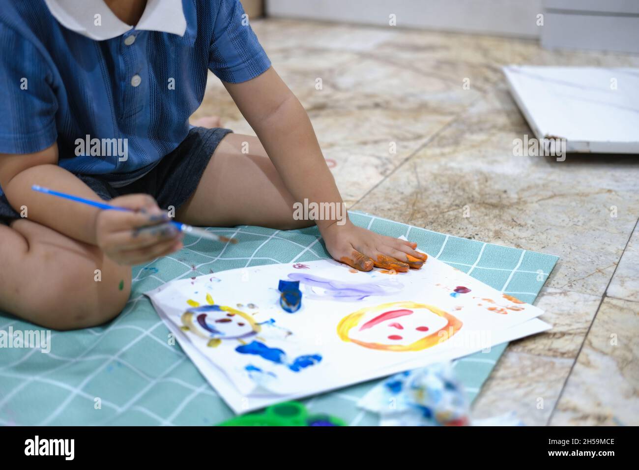 Focus on hands on paper, early childhood learning by using paints and ...