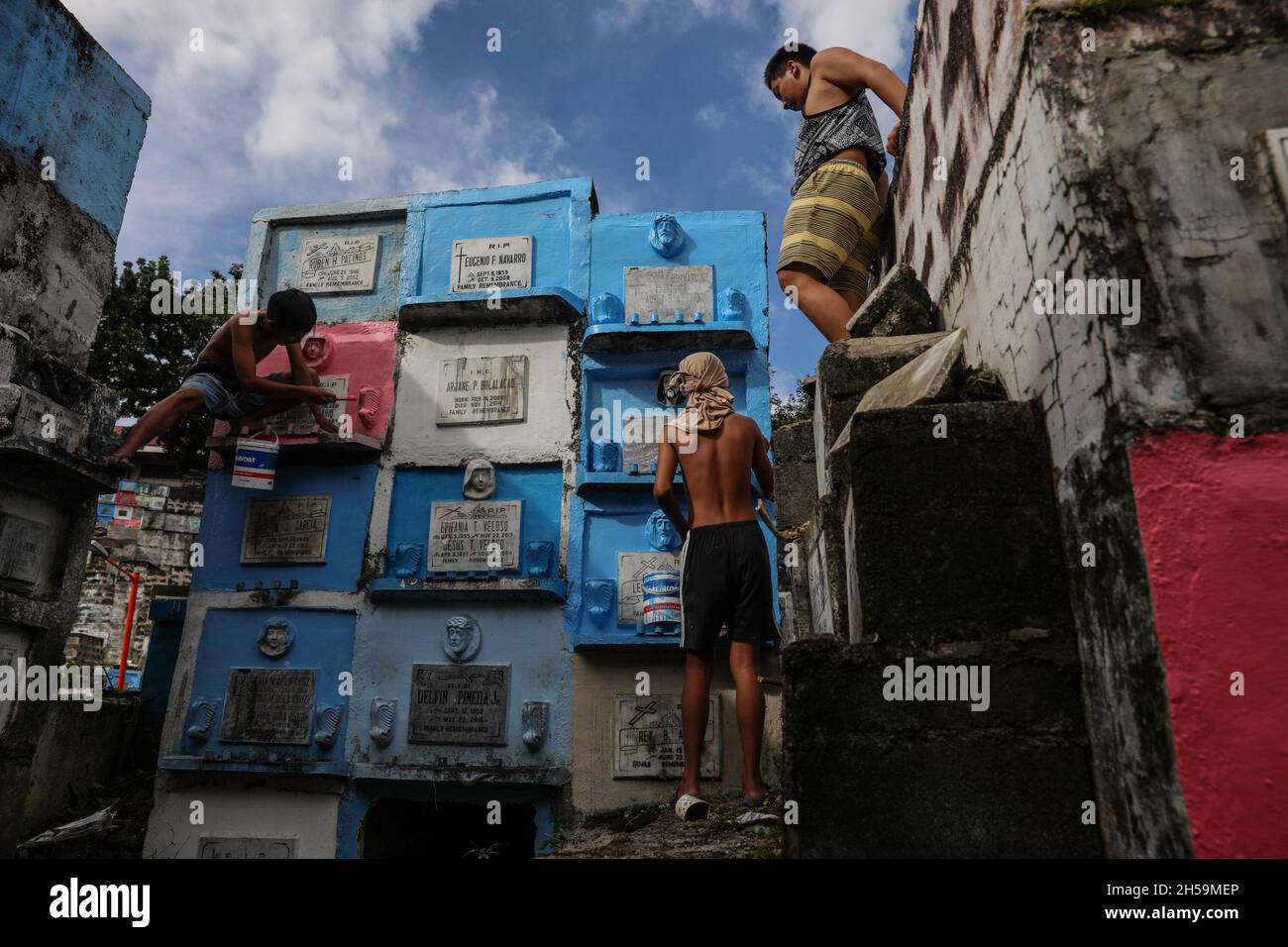 Workers refurbish stacked tombs as people visit cemeteries ahead of the ...
