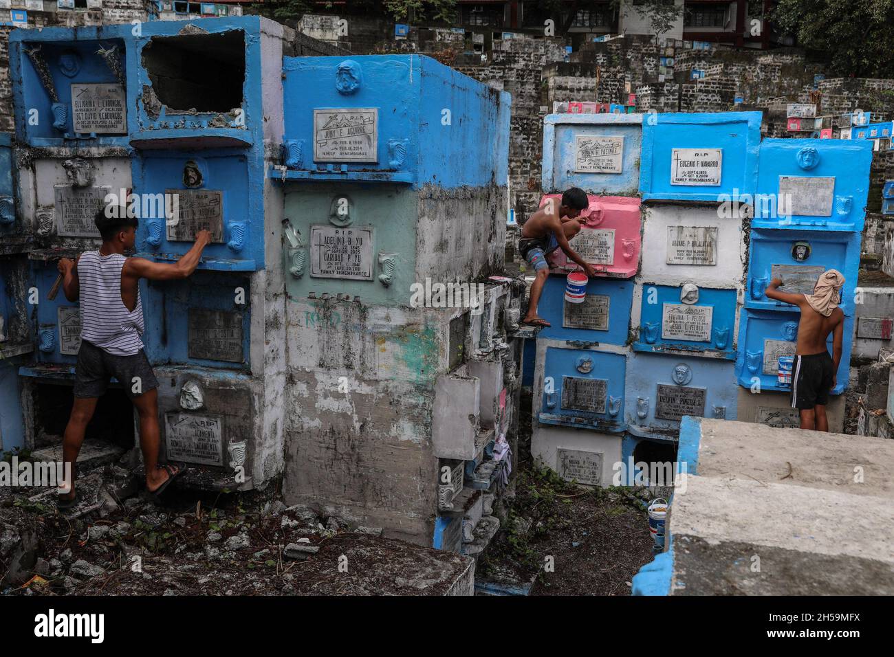 Workers refurbish stacked tombs as people visit cemeteries ahead of the ...