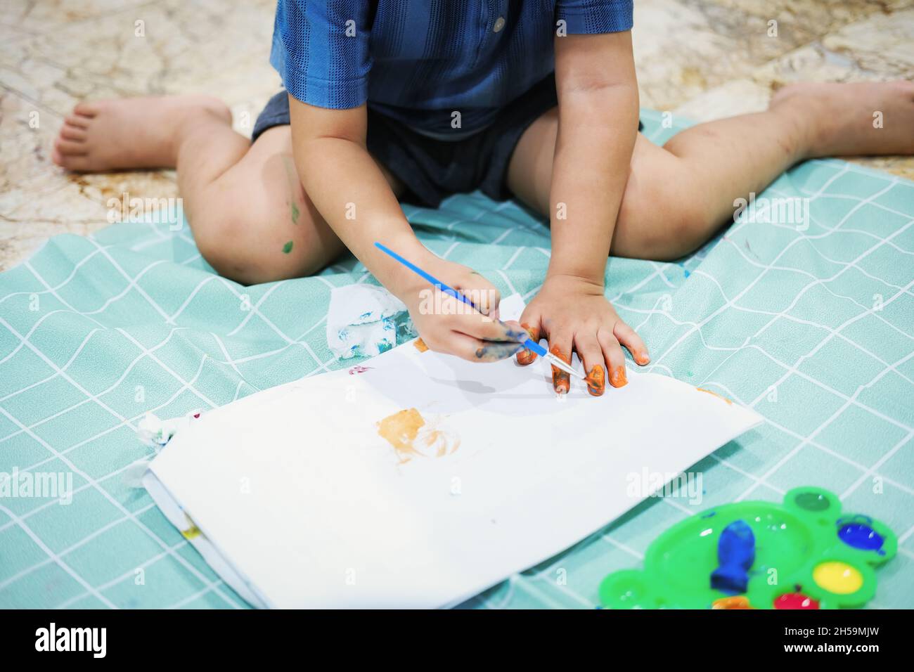 Focus on their hands on paper. Children use brushes to draw their hands ...