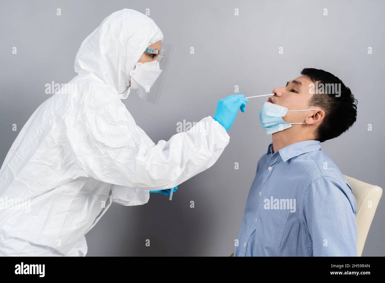 doctor with PPE suit test coronavirus(covid-19) to young man by nasal ...