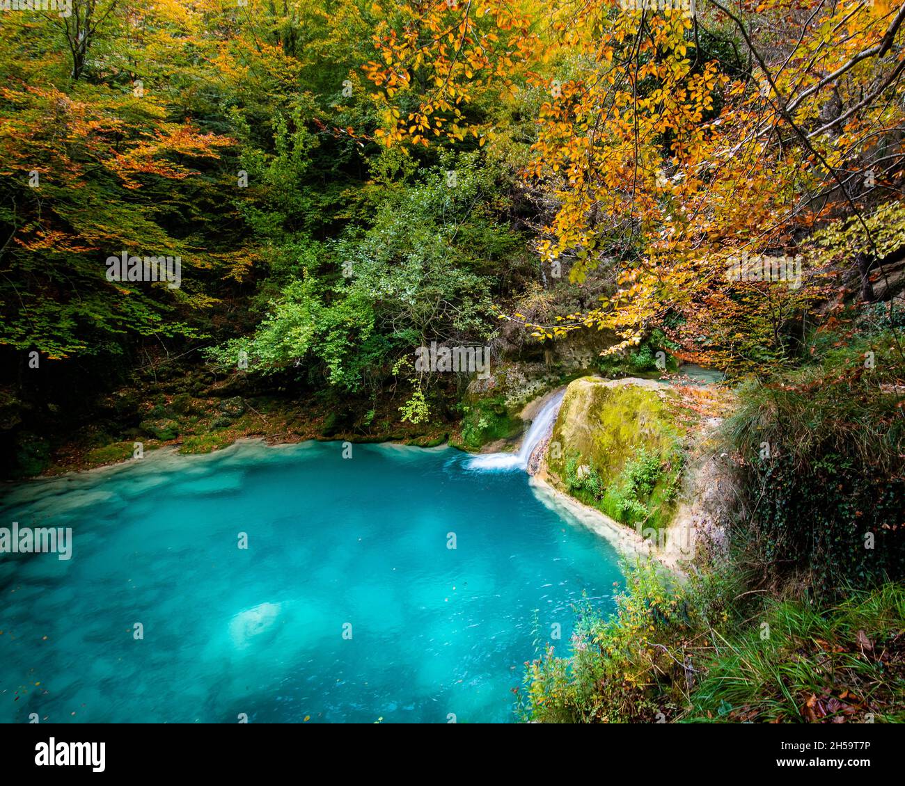 Forest turquoise blue lake with white marble stones and waterfalls in ...