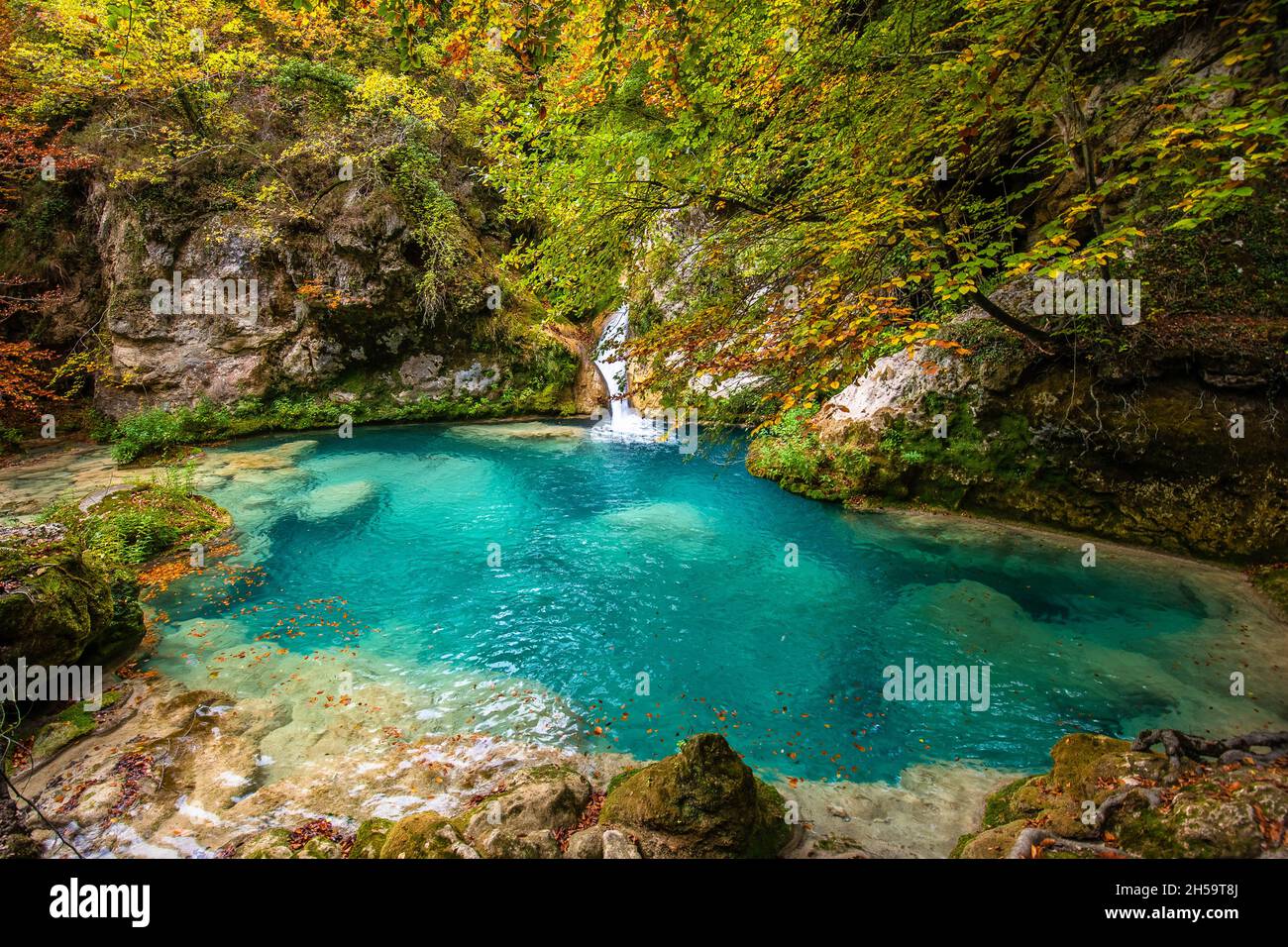 Forest turquoise blue lake with white marble stones and waterfalls in ...