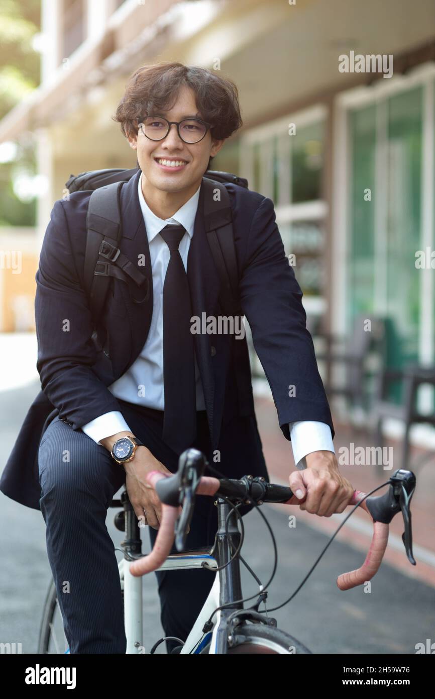 Portrait of young salary man ride bicycle to work. Urban male manager ...