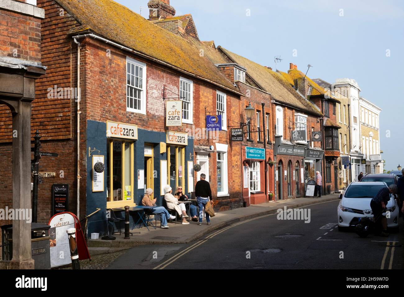 Row of shops, restaurants, cafes & people sitting outside Cafe Zara at ...