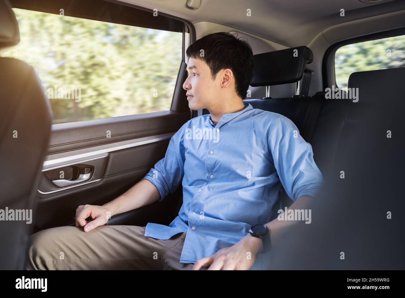 young man thinking and looking view out of window while sitting in the ...
