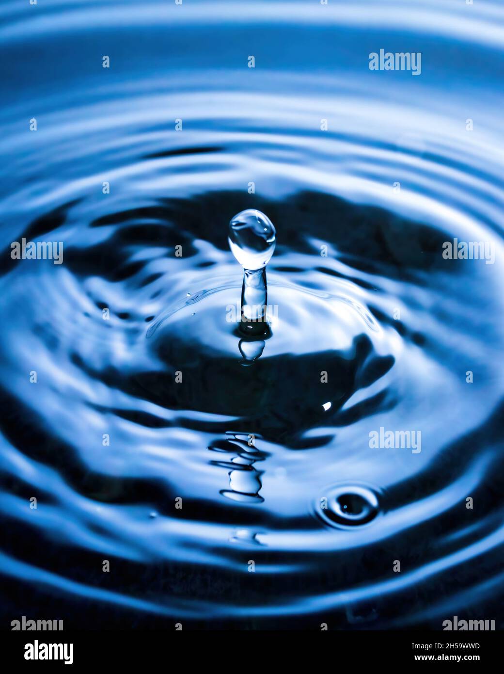 A drop of water and splashes with blurry waves on it Stock Photo - Alamy