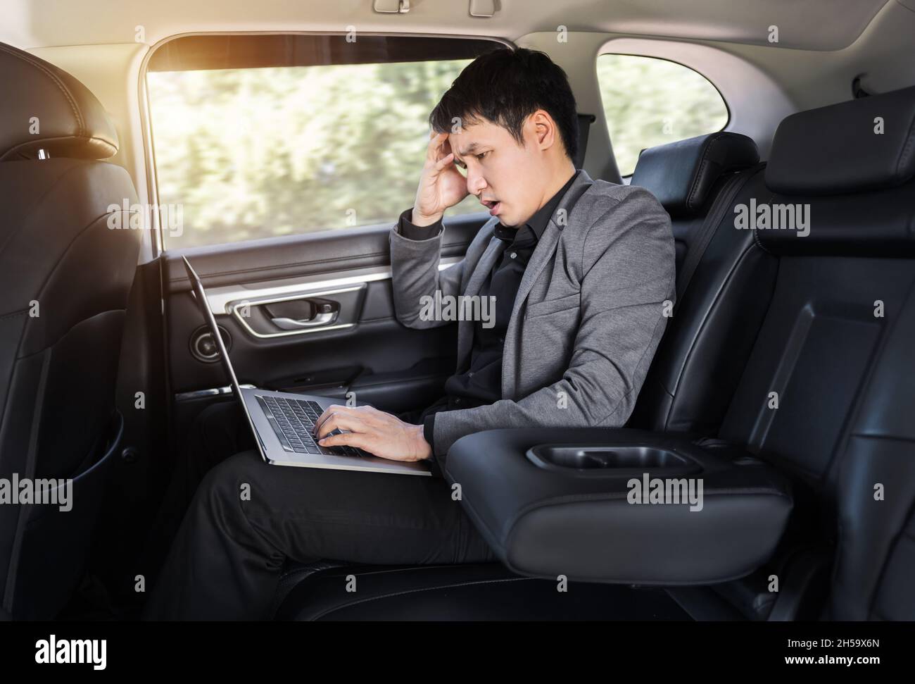 stressed young business man using laptop computer while sitting in the ...
