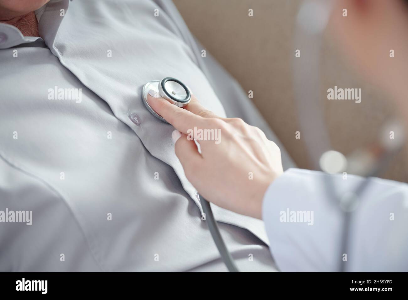 Patient breathing out when doctor putting chestpiece of stethoscope on ...