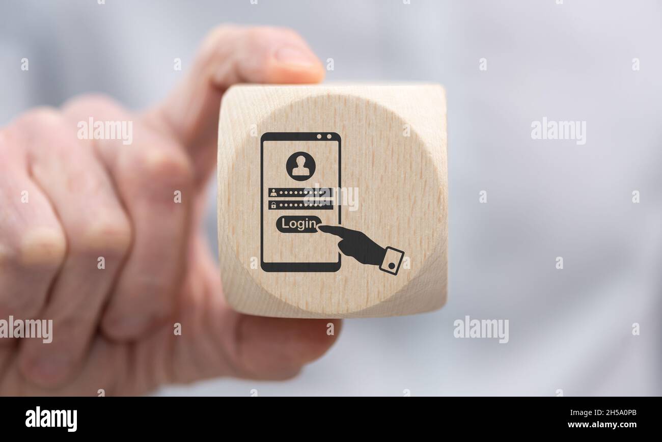 Hand holding a wooden cube with symbol of login concept Stock Photo - Alamy