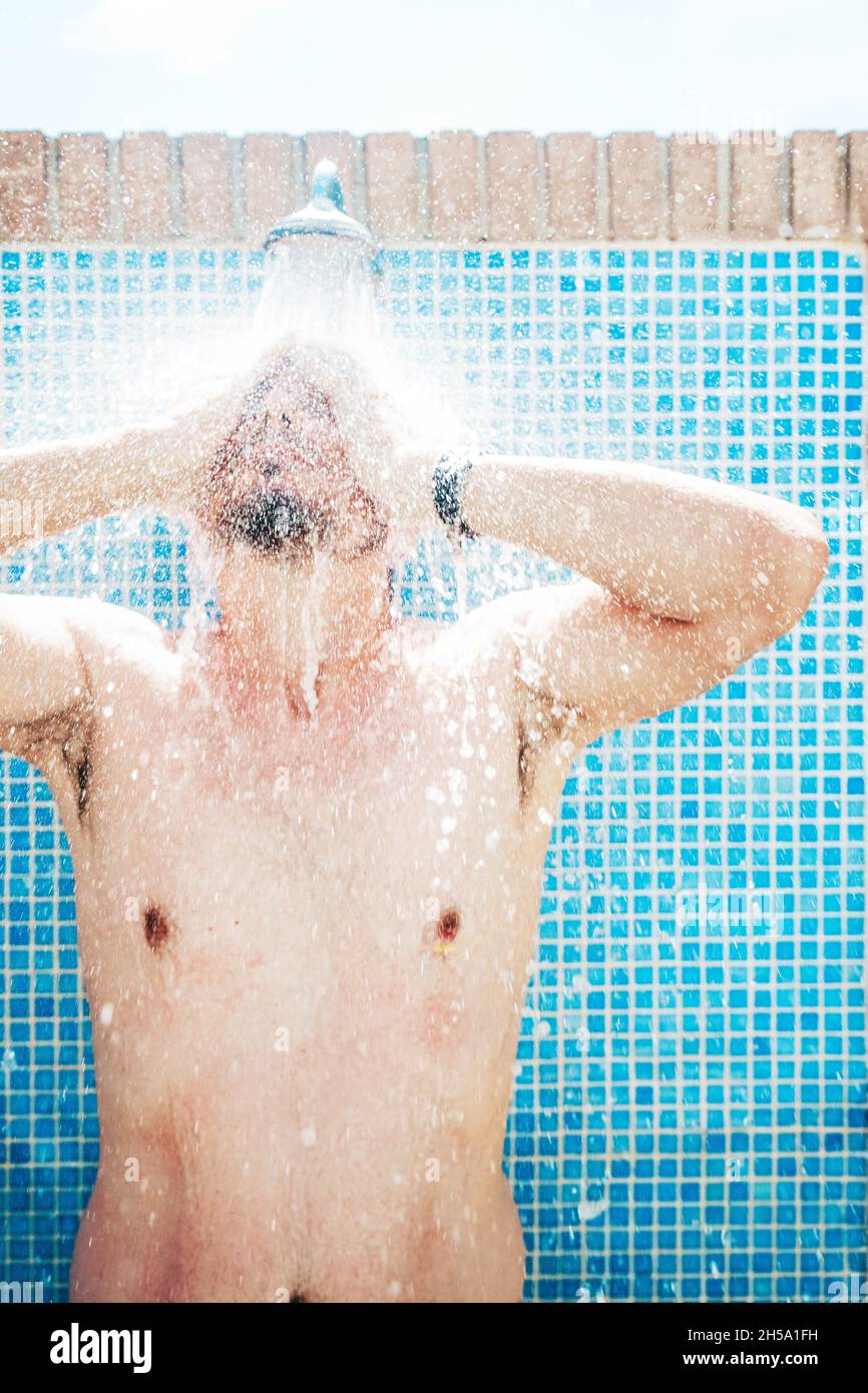 Young man having a shower before pool Stock Photo - Alamy