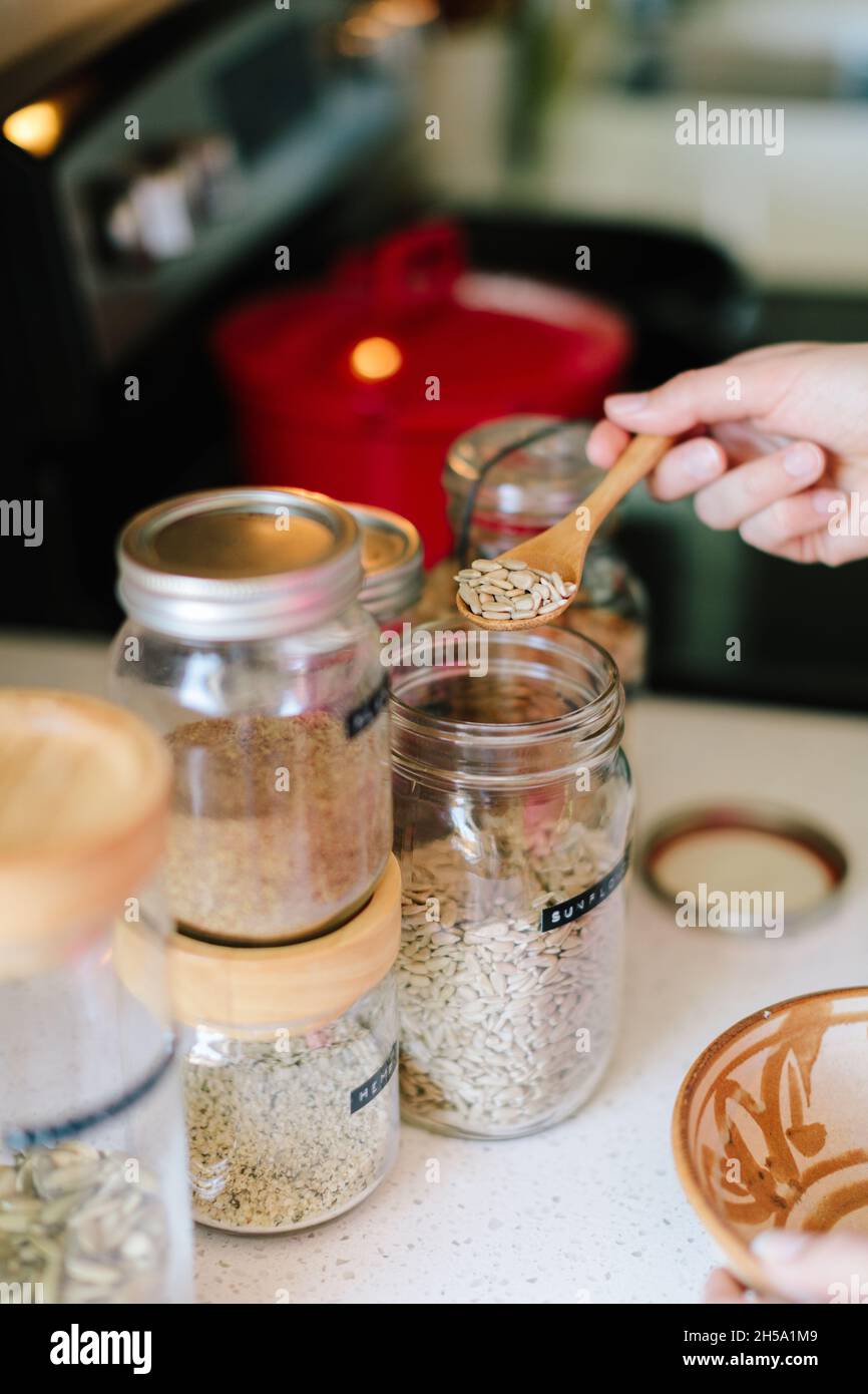 Vertical shot of a female taking a portion from a jar in the kitchen ...