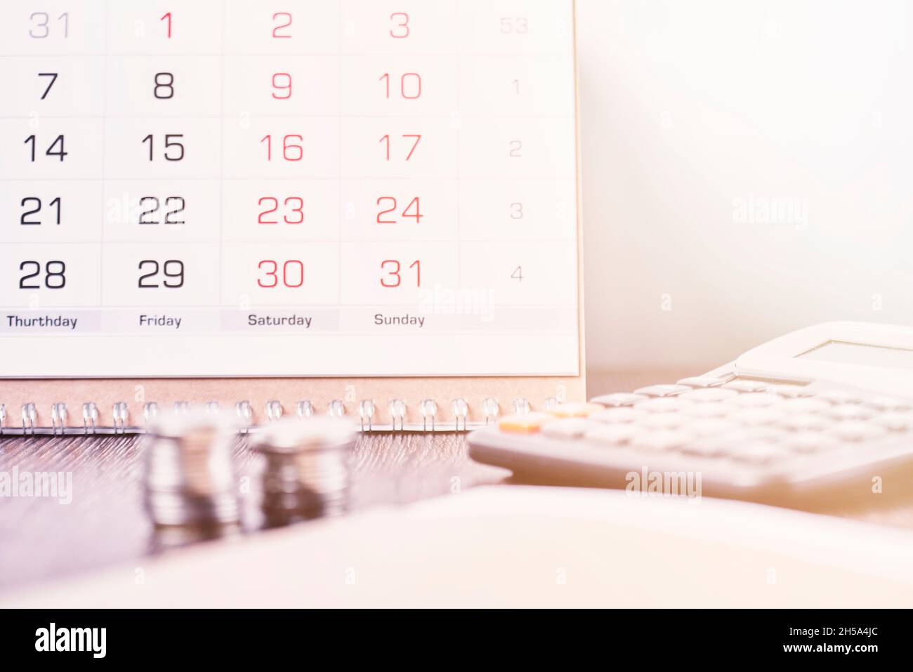 Calendar, calculator and stack of coins in office. Deadline concept ...