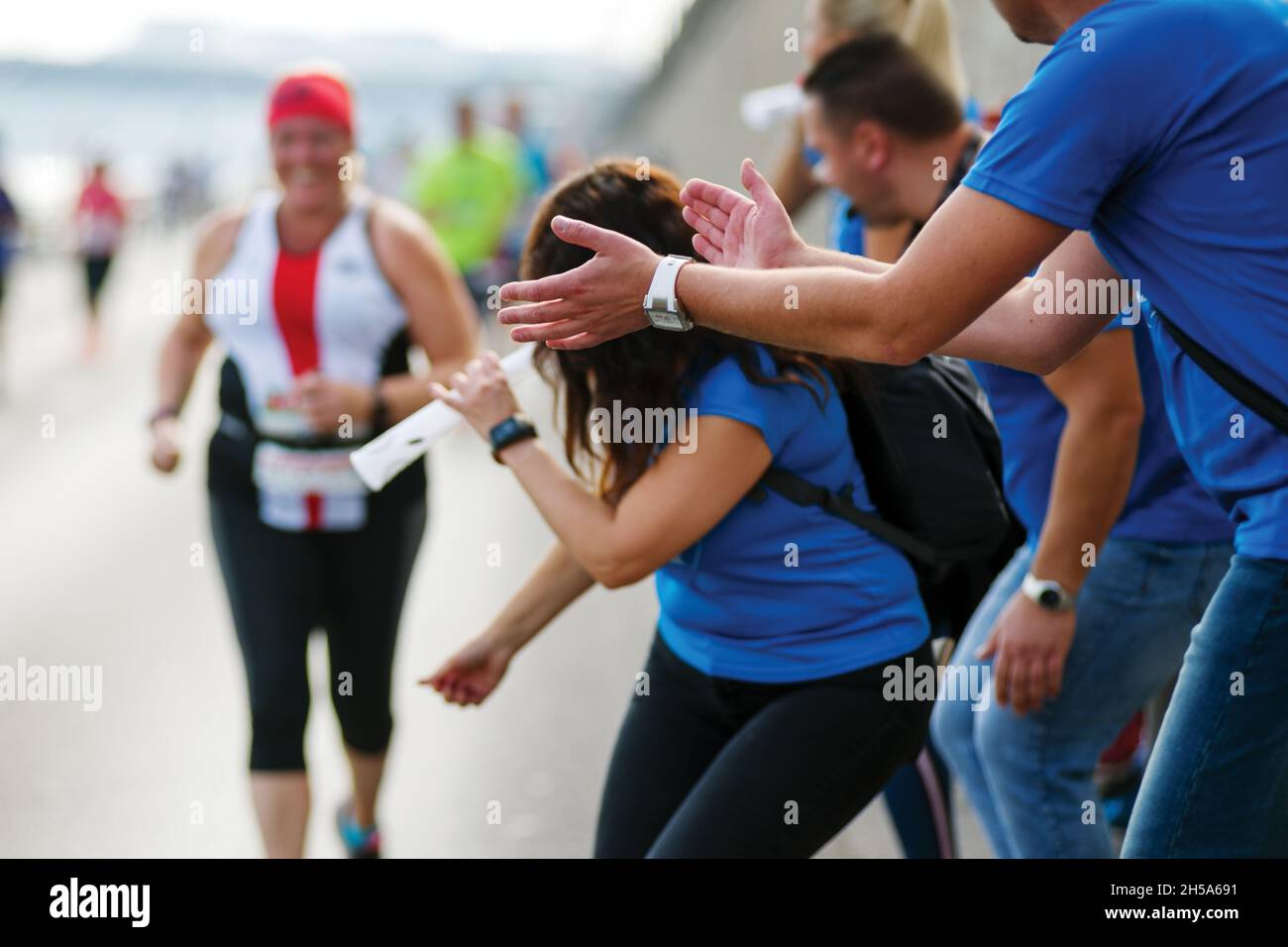 Fan group cheering up a marathon runner Stock Photo - Alamy