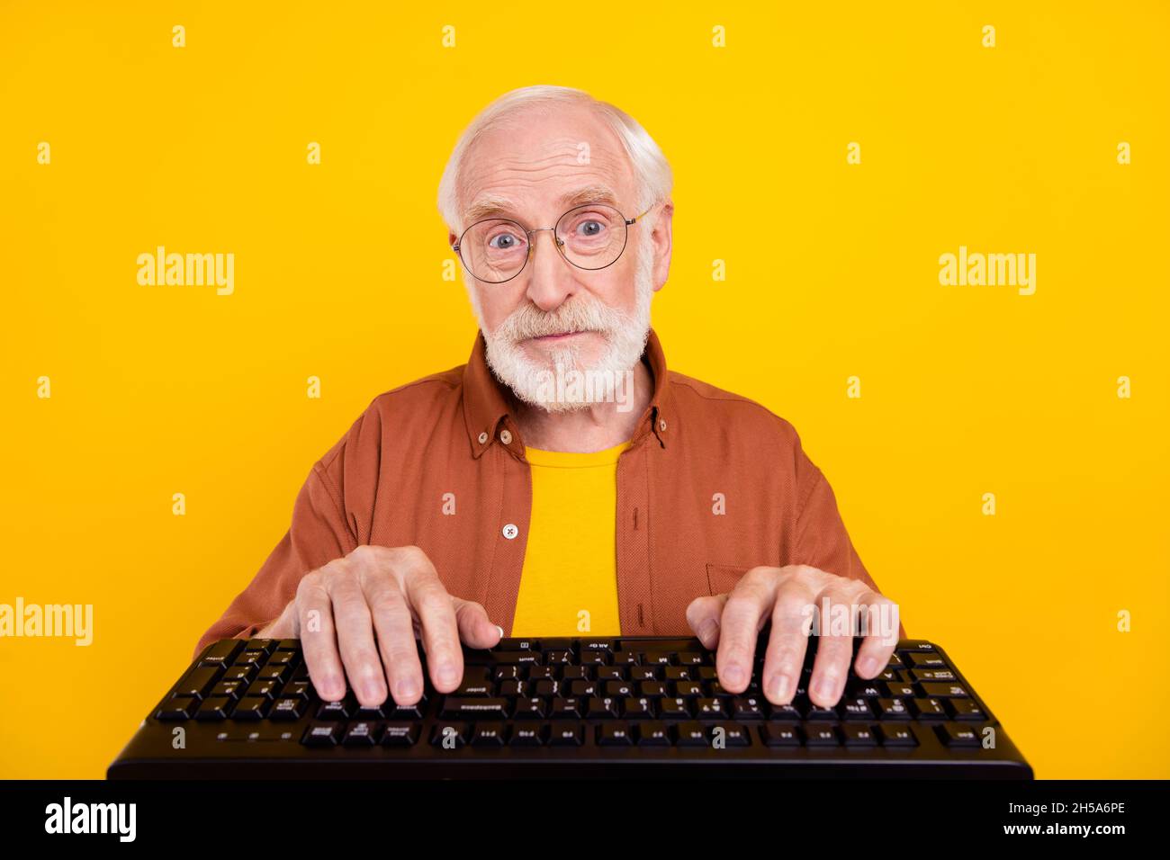 Photo of focused retired old man sit keyboard look webcamera wear specs ...