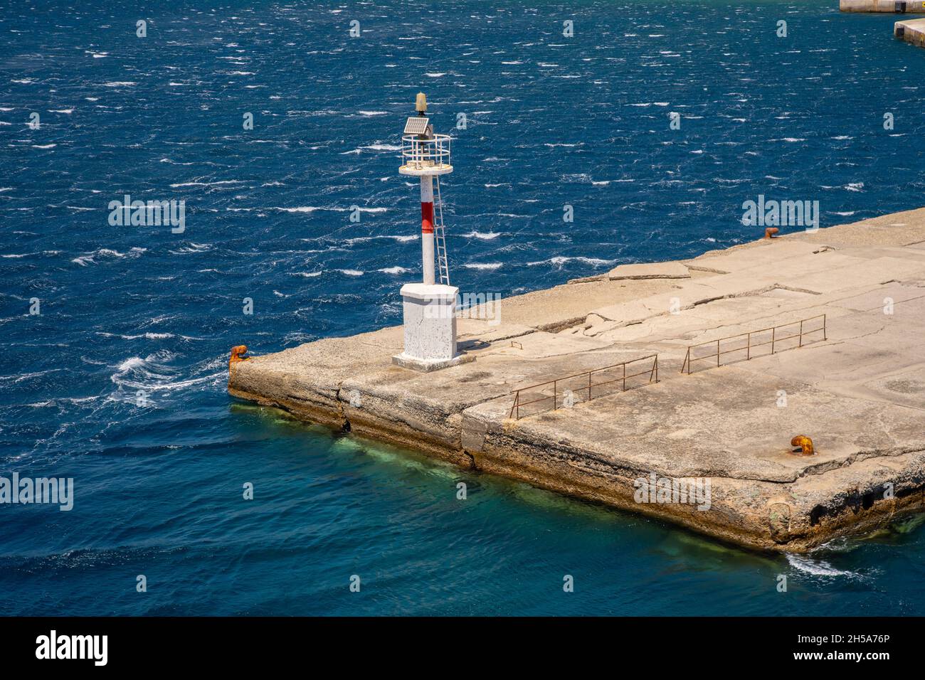The main dock and its lighthouse at the port of Tinos island,Greece ...