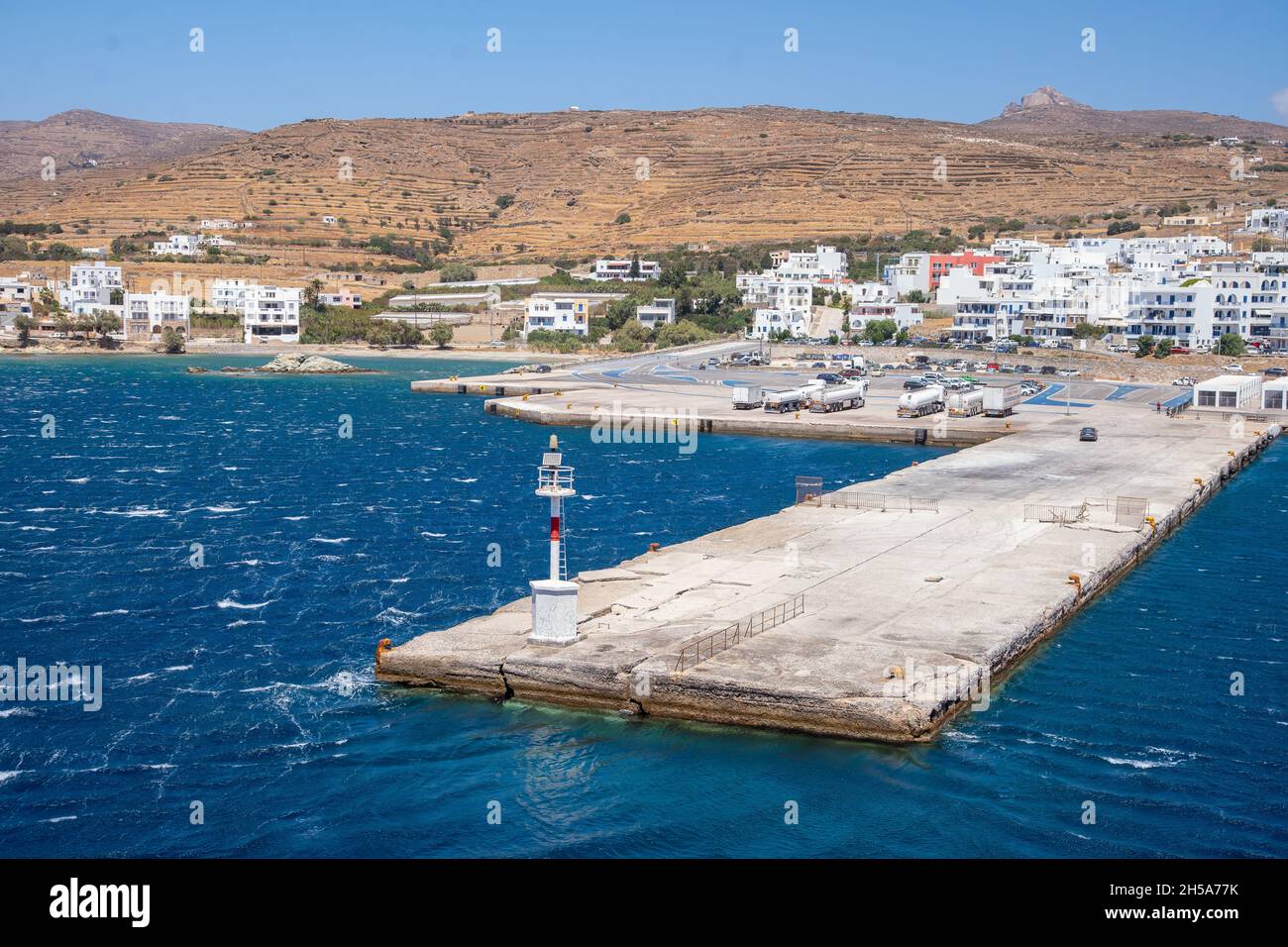 The main dock and its lighthouse at the port of Tinos island,Greece ...