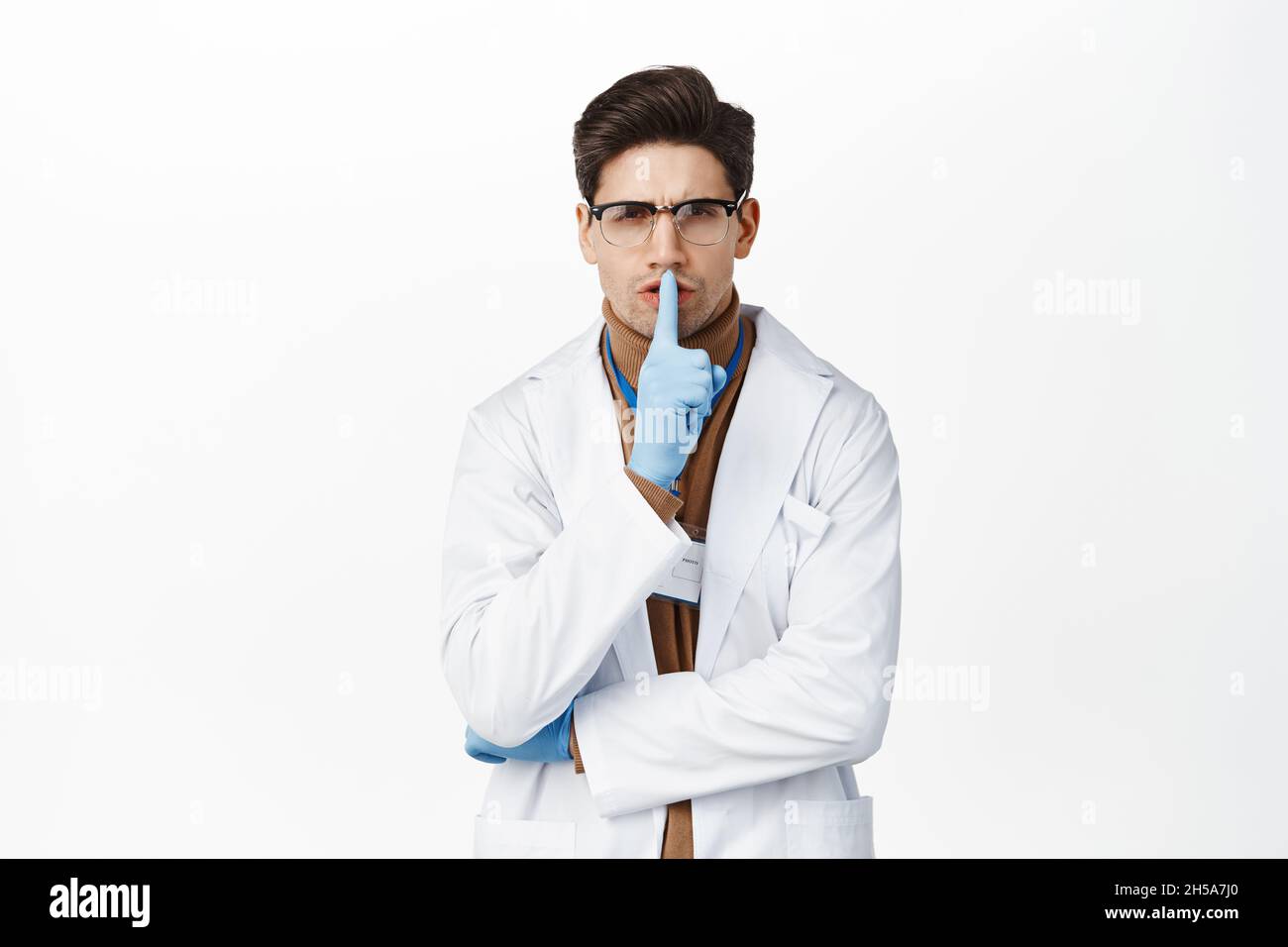 Angry doctor shushing, show taboo sign, press finger to lips and hush ...