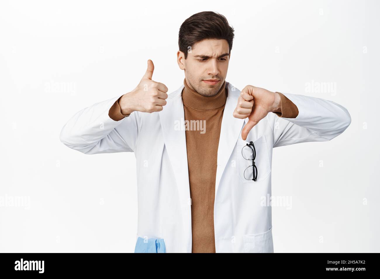 Indecisive doctor showing thumb up and thumb down, cant decide, making ...