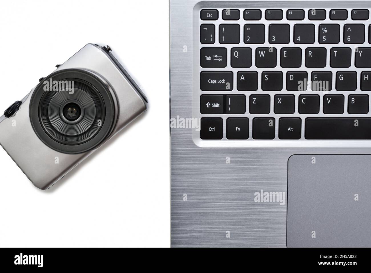 Laptop computer keyboard and photo camera on the desk. Digital devices ...