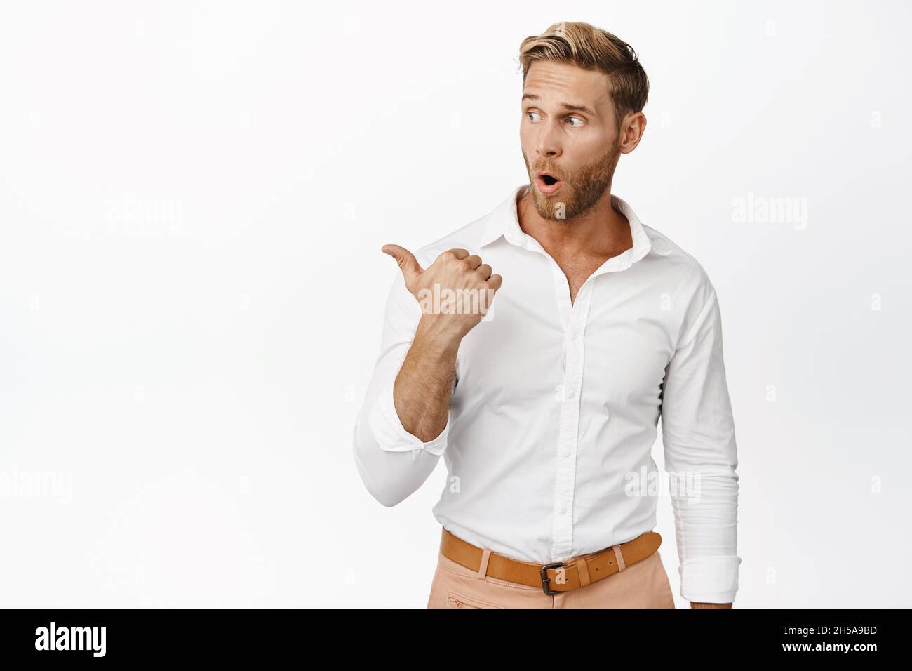 Image of surprised blond guy, pointing and looking left at ...
