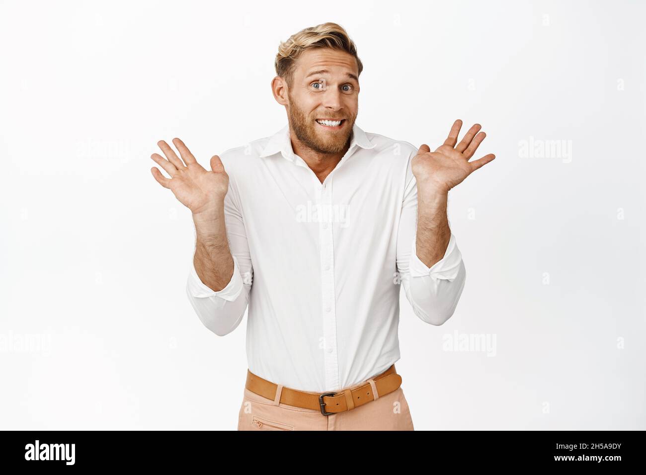 Sorry my bad. Handsome blond man raising hands and smiling awkward ...