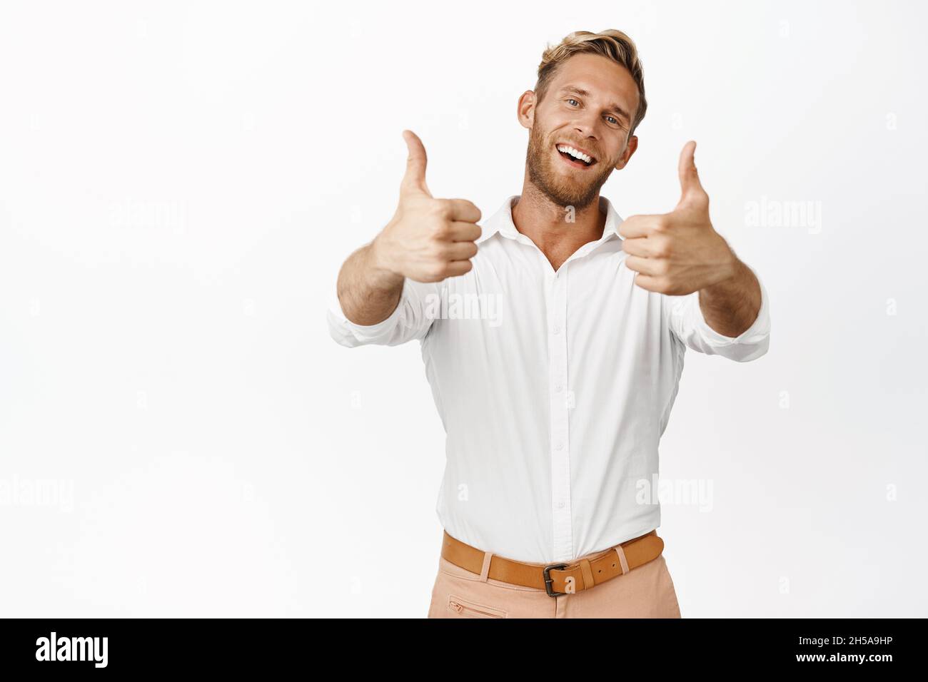 Enthusiastic business man winking and smiling with thumbs up, wearing ...