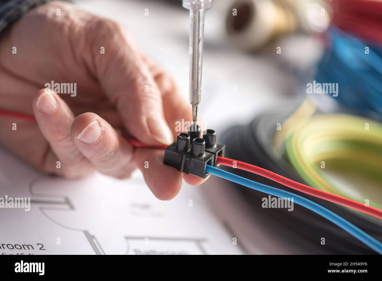 Electrician hands connecting wires in terminal block Stock Photo - Alamy