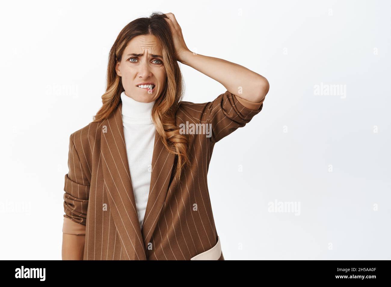 Complicated woman looking troubled, touching head and staring puzzled ...