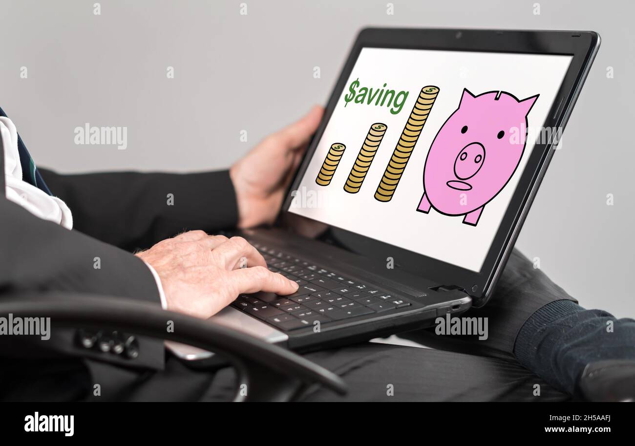 Businessman watching saving concept on a laptop Stock Photo - Alamy