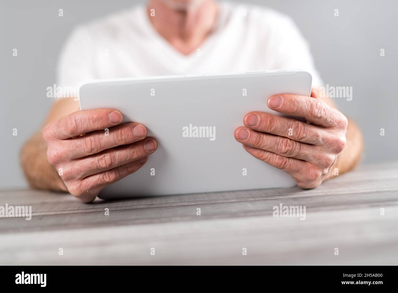 Man sitting using a tablet Stock Photo - Alamy