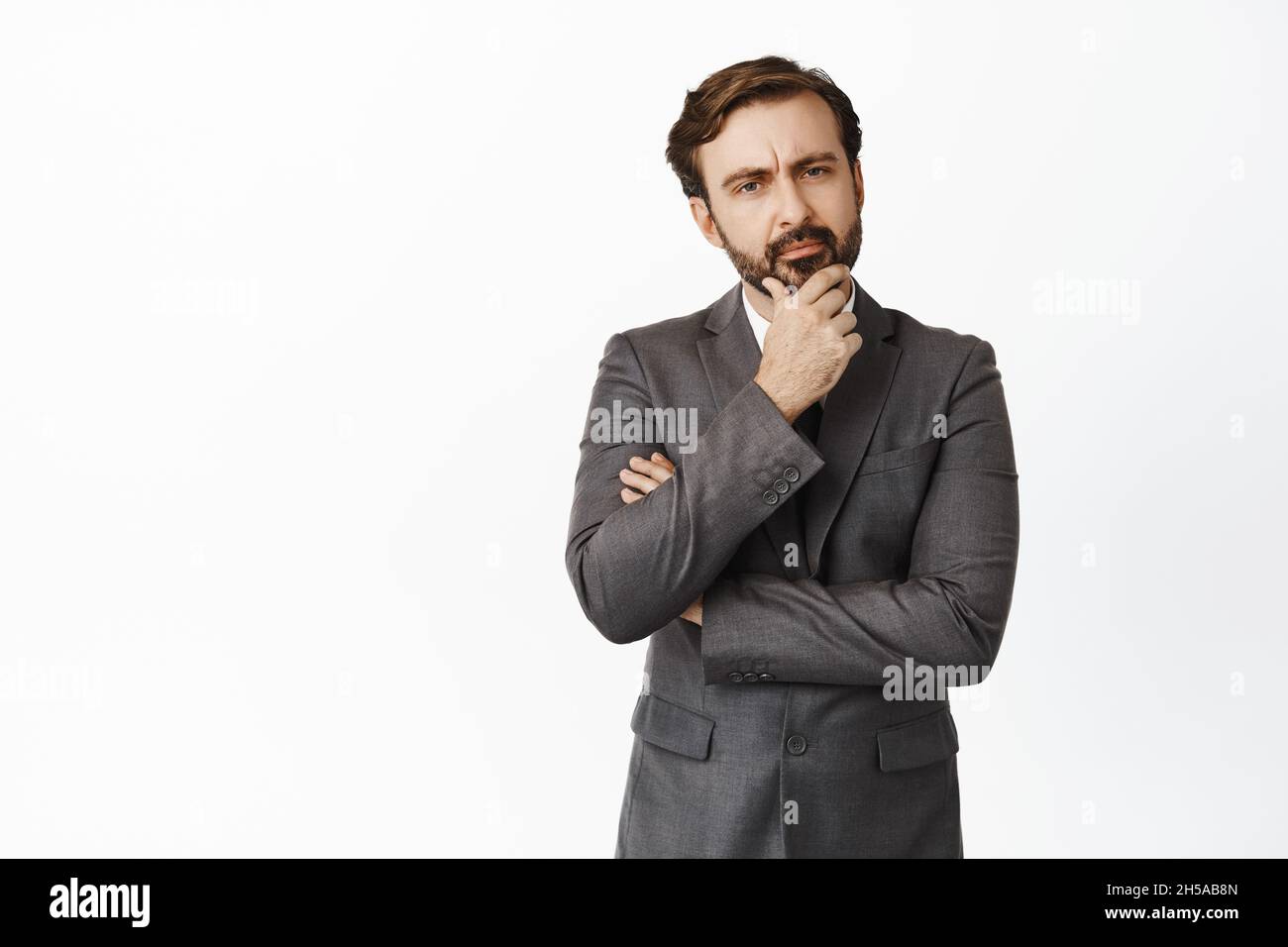 Image of salesman in corporate suit, looking at camera thoughtful ...